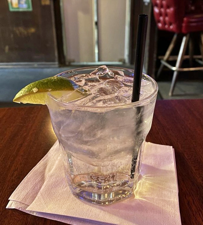 A pristine gin and tonic, garnished with lime, awaits its destiny as the perfect companion to your steak—simple, elegant, and utterly necessary.