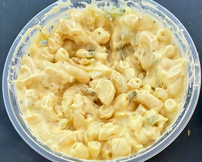 Not your standard mac and cheese—this version has green bits of flavor that elevate it from cafeteria staple to comfort food royalty.