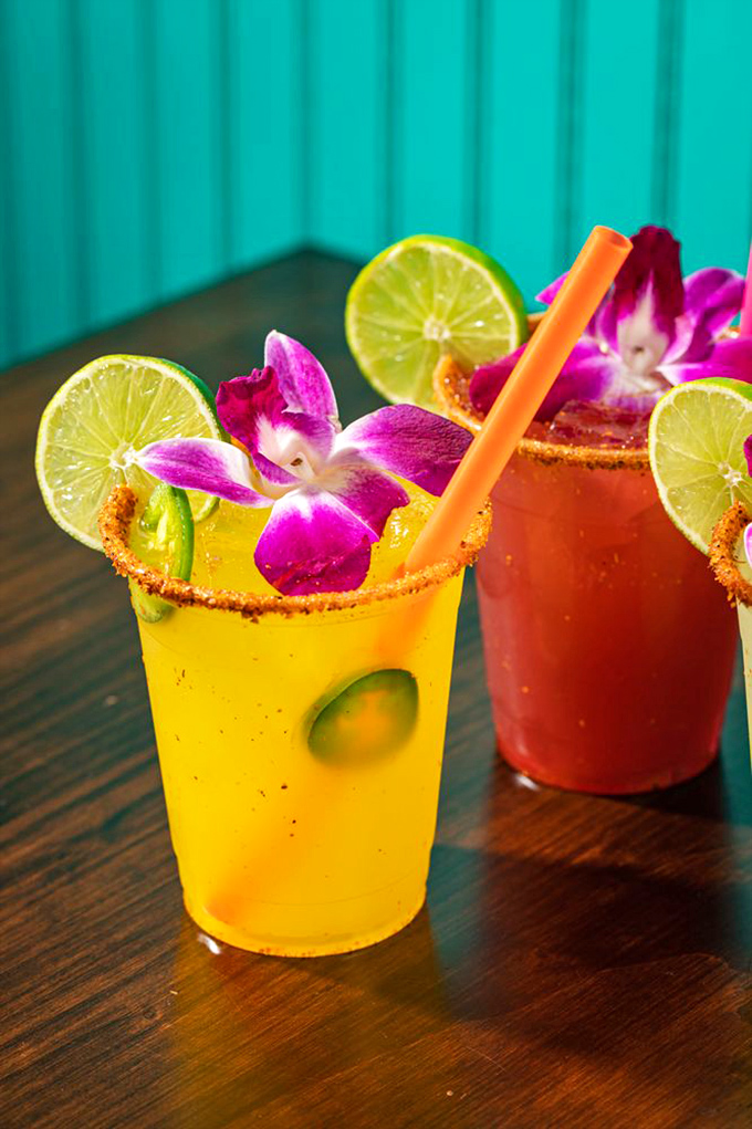 Margaritas dressed for their own quinceañera. These vibrant cocktails with their flower garnishes and tajin rims are ready for their Instagram moment.
