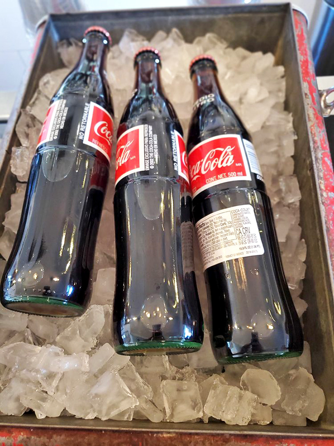 Mexican Colas lounging in their ice bath like celebrities at a spa—real sugar, glass bottles, and a taste that makes regular sodas seem like they're not even trying.