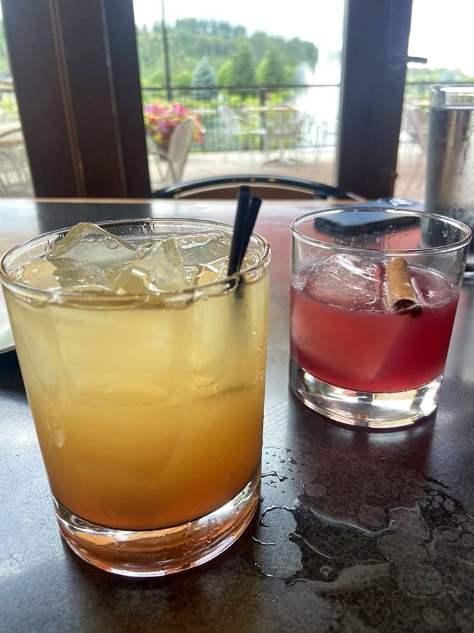 Cocktails with a view—liquid sunshine in a glass alongside what appears to be a classic negroni. The perfect companions for lakeside contemplation.