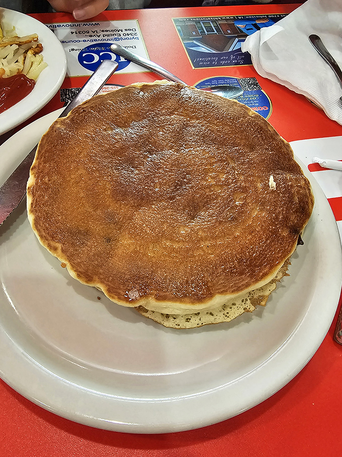 This pancake isn't just big—it's the solar system of breakfast, with its own gravitational pull and enough surface area for syrup exploration.