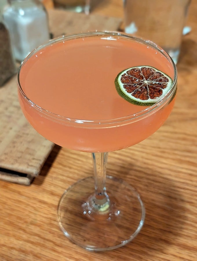 This blush-colored cocktail isn't just Instagram-worthy—it's a refreshing counterpoint to the rich comfort foods. The lime garnish adds just the right zing.