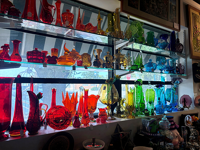 A rainbow of vintage glassware catches the light like a time-traveling prism, each piece telling colorful stories of dinner parties past.