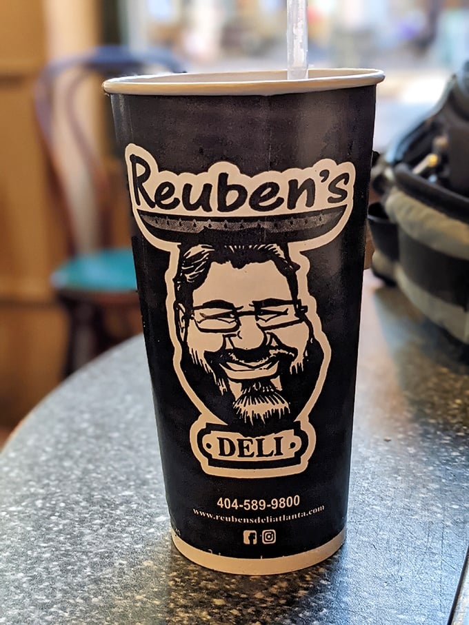 That cup isn't just holding coffee—it's carrying liquid motivation with the smiling face of deli satisfaction on its side.