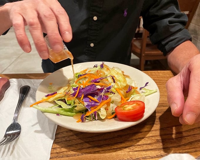 A fresh salad getting dressed tableside—proof that even in steak country, vegetables can have their moment in the spotlight.