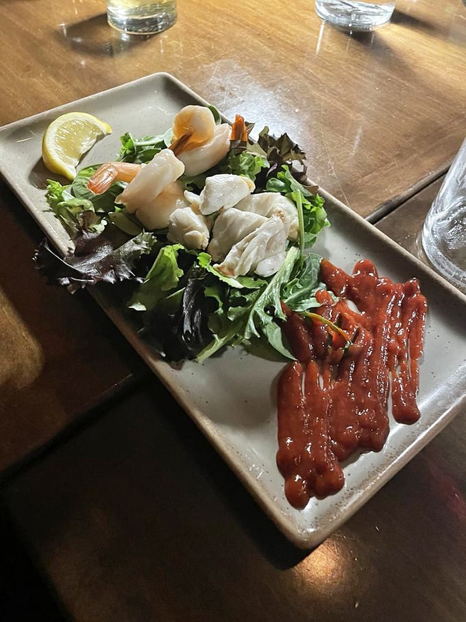 Ocean treasures nestled on fresh greens with artistic sauce flourishes—seafood this elegant makes Monday feel like Saturday night.