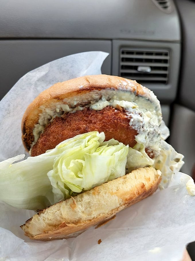 A study in textural contrast: crispy exterior, tender interior, fresh lettuce. This burger understands the architecture of deliciousness.
