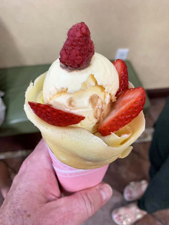 Ice cream, fresh berries, and delicate crepe—the holy trinity of dessert perfection. This handheld happiness makes spoons everywhere feel utterly inadequate.