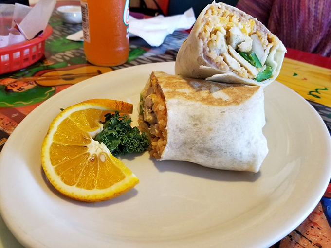 This burrito isn't just wrapped—it's embraced by a flour tortilla that knows exactly what it's doing. The orange slice adds a touch of sunshine.