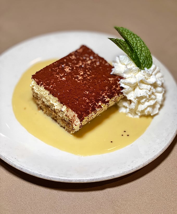 Dessert that doesn't try too hard—just classic tiramisu with the perfect balance of coffee, cream, and cocoa, served with a mint leaf crown.