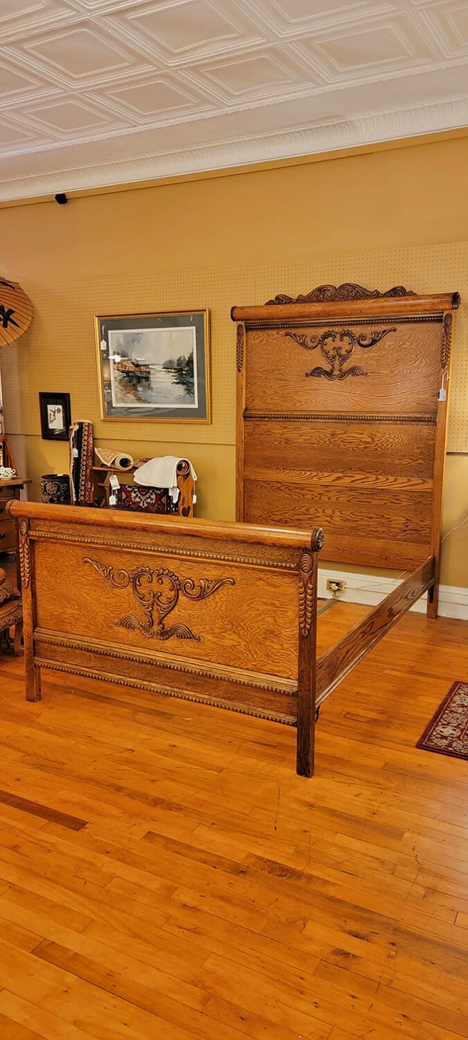 Carved oak headboard telling stories of dreams from another century, when craftsmanship wasn't just a marketing buzzword but a way of life.