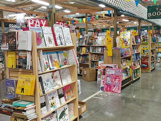 A bibliophile's dream come true—shelves stacked with everything from children's classics to regional cookbooks. The "PRAY" sign seems appropriate for those praying to find space for more books.