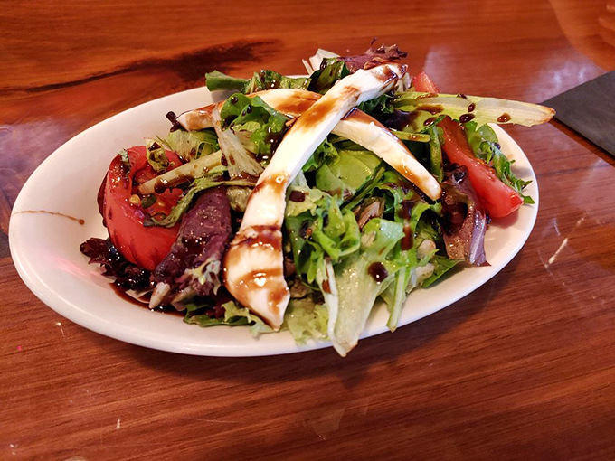 A salad that actually excites—fresh greens, vibrant tomatoes, and cheese that wasn't born in a factory. Proof that vegetables can be the life of the party.