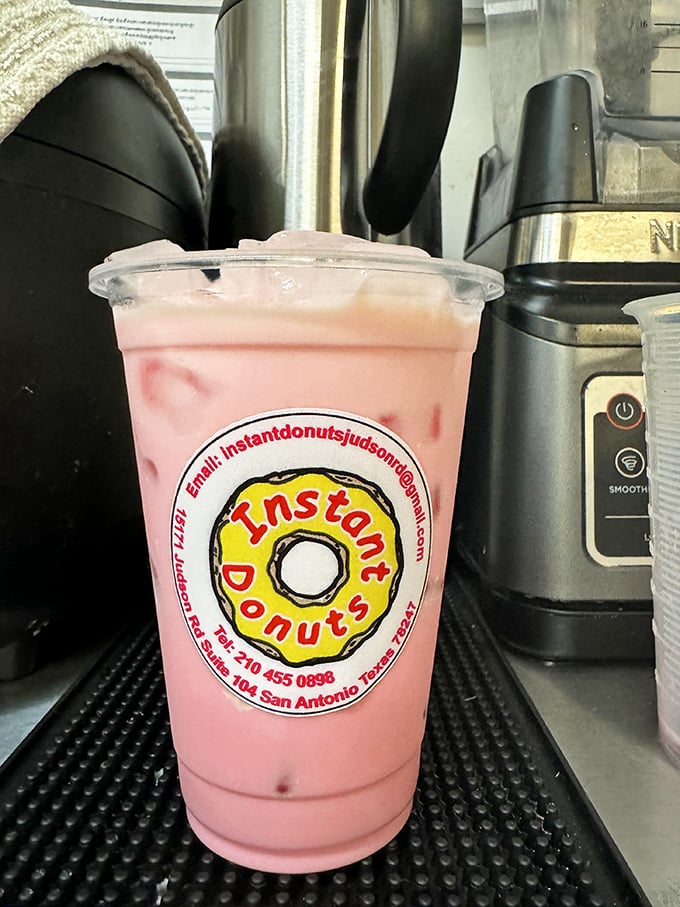 That pink drink isn't just refreshment, it's liquid optimism in a cup, complete with the cheerful Instant Donuts logo promising sweet sips ahead.