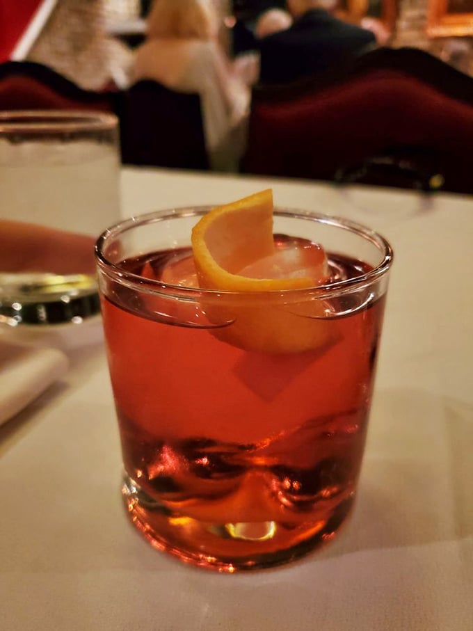 A perfectly crafted cocktail with an orange twist catching the light. This isn't just a drink—it's liquid anticipation before the main event.