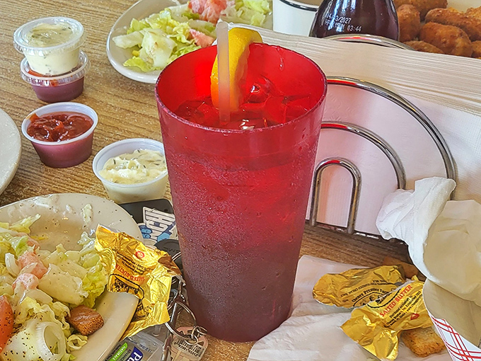 That crimson drink isn't just refreshing—it's the perfect counterpoint to a seafood feast, like a sunset in a glass.