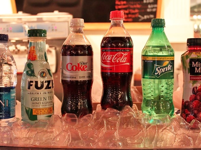 Classic sodas lined up like old friends at a reunion—each bottle promising the perfect complement to your frozen indulgence.