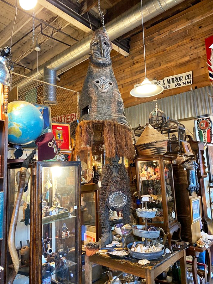That tribal mask hanging from the ceiling isn't just decor—it's the store's unofficial guardian, keeping watch over treasures from seashells to globes to vintage display cases.