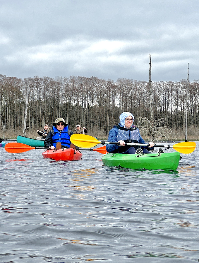 Colorful kayaks dot Black Bayou Lake as paddlers explore nature's playground – no expensive gym membership required for this full-body workout with a view.