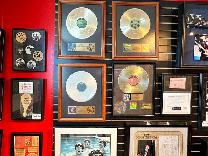 Gold records gleam against the crimson wall, each disc representing millions of fans who made Beatles history. Shine on, you crazy diamonds.