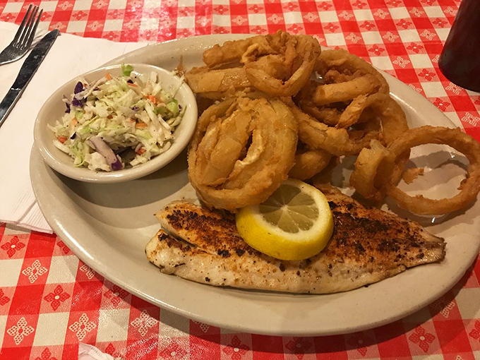 Perfectly grilled fish with a squeeze of lemon, crispy onion rings, and fresh slaw—proof that Mississippi knows its seafood as well as its meat.