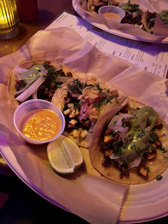 Tacos presented with the care of tiny edible art installations. The bright garnishes aren't just pretty—they're flavor fireworks waiting to explode.