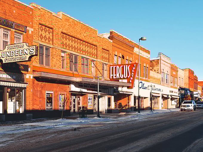 Morning light bathes Fergus Falls' brick storefronts in golden warmth, highlighting the vintage theater marquee that still draws weekend crowds.