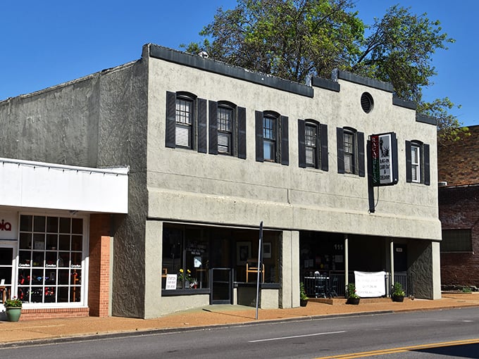 Those black shutters frame a stucco canvas where pizza artistry happens daily – no subway ride required.