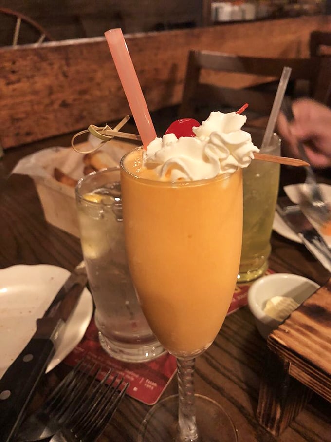 The Barn Bellini—a sunset-colored cocktail topped with whipped cream and a cherry that says, "Yes, you deserve this."