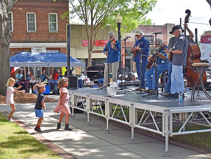 These bluegrass musicians aren't just playing songs—they're keeping traditions alive while kids dance with the kind of freedom only small-town festivals allow.