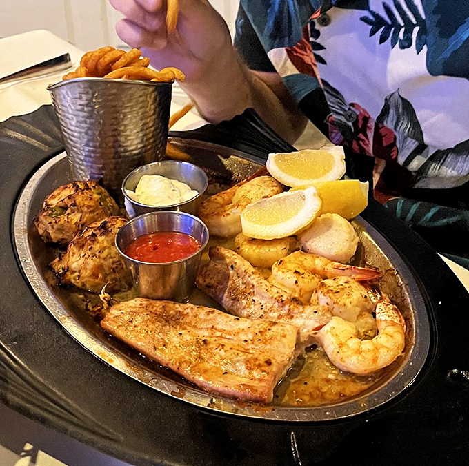 A seafood platter so generous it deserves its own ZIP code—complete with crab cakes that look like they're auditioning for a Food Network show.