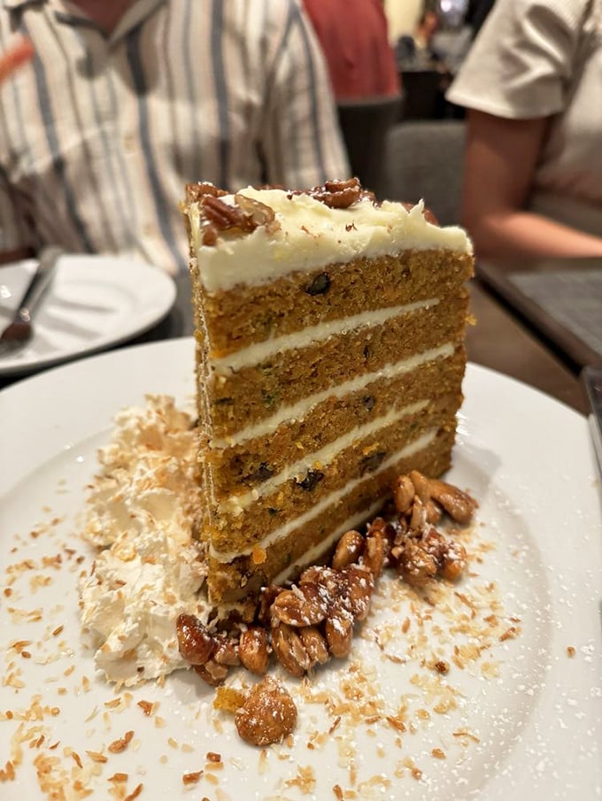 Carrot cake reimagined as a towering architectural achievement. Those candied pecans aren't just garnish—they're the crown jewels.