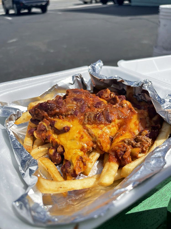 Chili cheese fries served in checkered paper – because sometimes the messiest foods require the most festive presentation.
