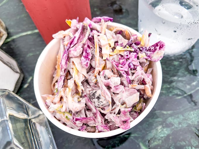Not just any coleslaw, but a vibrant purple-tinged masterpiece that cuts through the richness of fried food like a refreshing breeze.