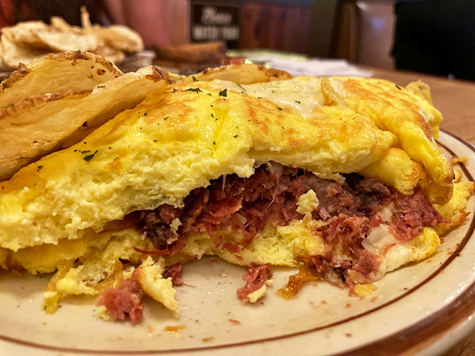 A cross-section revealing the inner architecture of a perfect corned beef hash omelet – a blueprint worth framing or, better yet, devouring.