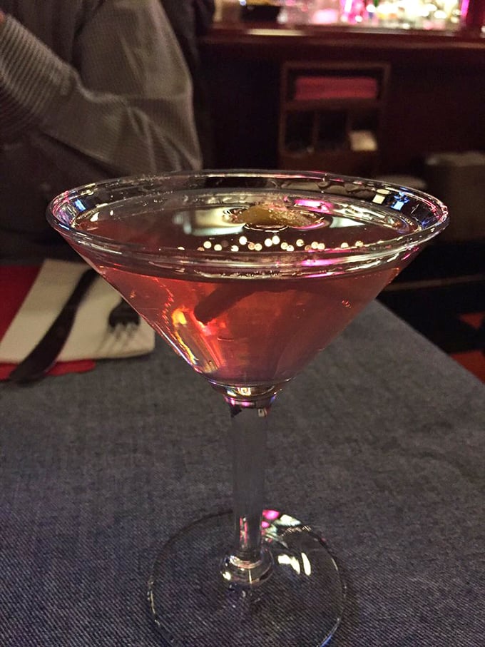 A perfectly mixed cosmopolitan waiting patiently at the table—because sometimes you need something civilized before descending into delicious burger madness.