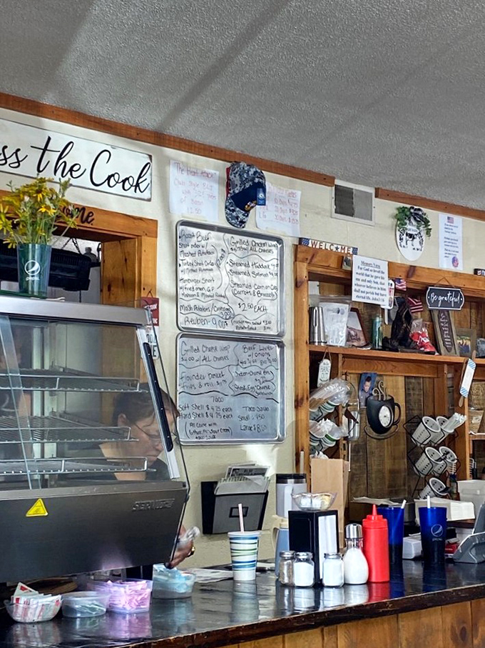 The "Kiss the Cook" sign isn't just cute decor—it's sound advice after experiencing what happens behind that counter.