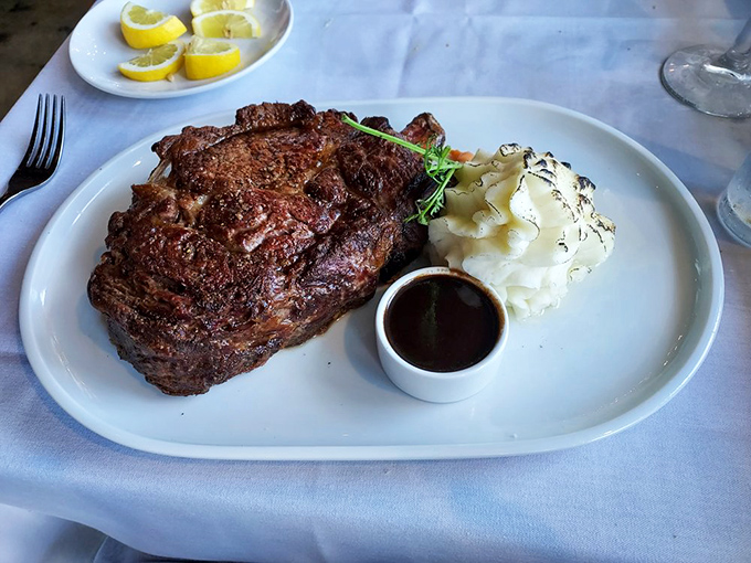 This magnificent ribeye isn't just dinner—it's an event, with that sauce cup standing by like a loyal sidekick ready for action.