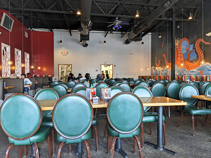Teal chairs pop against red walls in this dining area, where an octopus mural watches over diners like a friendly sea guardian.