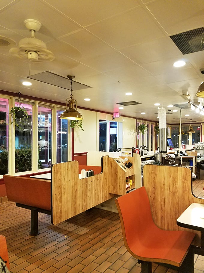 Orange booth seating and wooden dividers create the perfect balance of privacy and community – diner architecture that understands human nature.