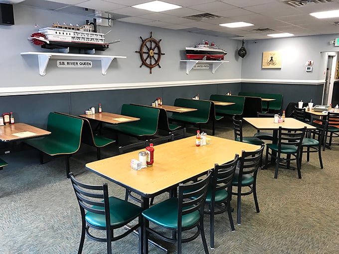 Nautical-themed walls watch over green booths where breakfast dreams come true – a dining room that feels like coming home.
