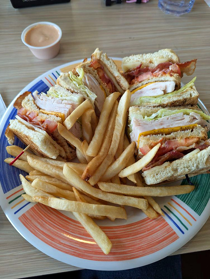 The club sandwich—architecture you can eat. Stacked higher than your weekend plans and flanked by fries standing at attention.