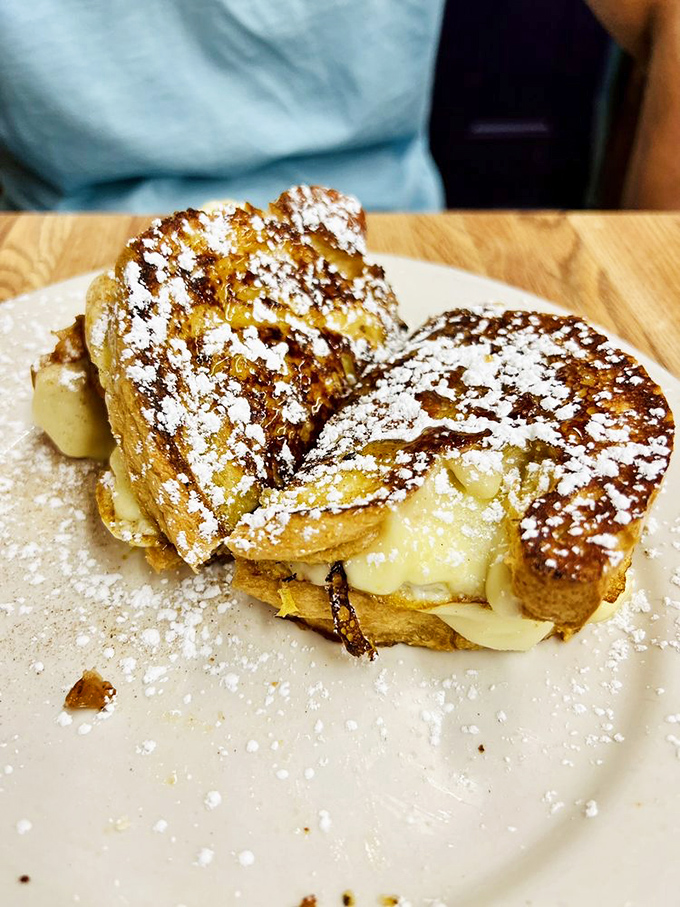 French toast that's having an identity crisis as dessert. Powdered sugar snowfall on golden bread mountains—breakfast has never looked so indulgent.