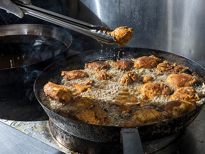 The sacred ritual of pan-frying—bubbling oil cradles seasoned chicken in cast iron, transforming humble poultry into transcendent crunch.