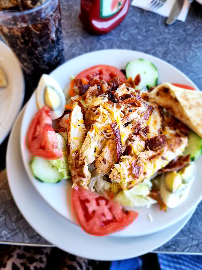 A grilled chicken salad that actually makes eating healthy look appealing—surrounded by fresh tomatoes and cucumbers like a protein-packed island paradise.
