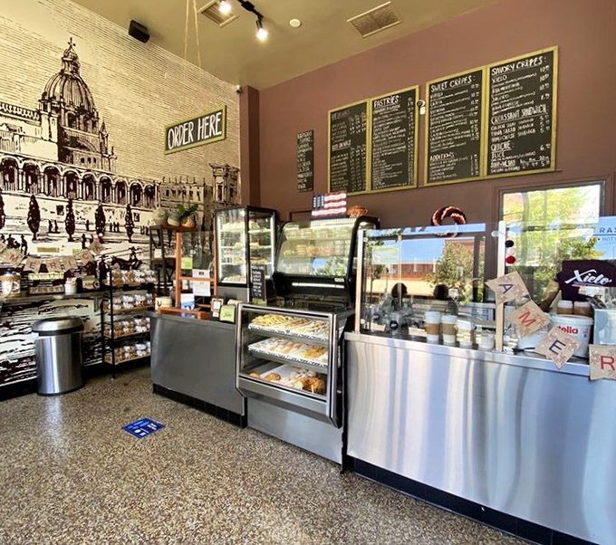 The interior feels like a European café that somehow landed in Oxnard, complete with architectural mural and display cases of temptation.