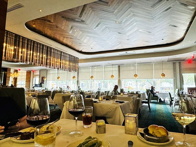 The herringbone ceiling watches over diners like a wooden guardian angel as golden pendant lights cast the perfect glow for important decisions.