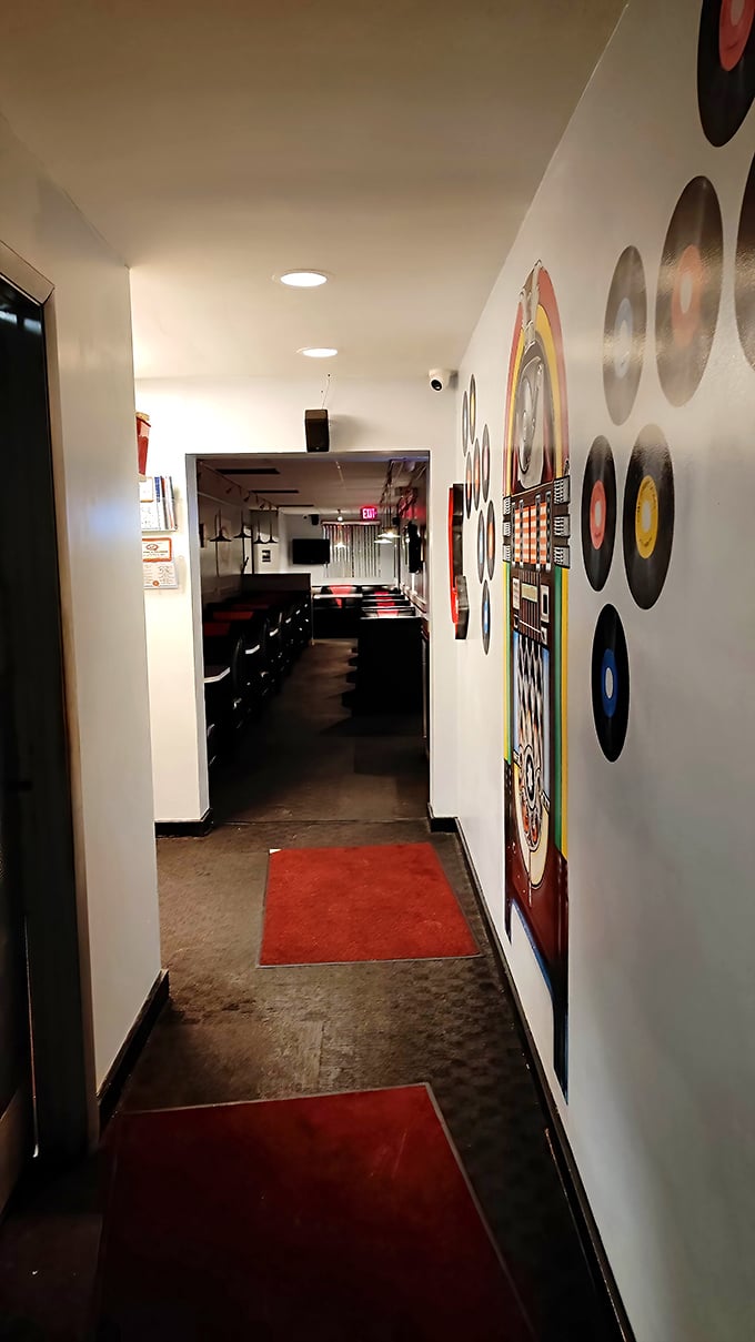 The hallway's vinyl record décor and classic diner aesthetic whisper promises of comfort food that's been perfected over decades, not designed for Instagram.