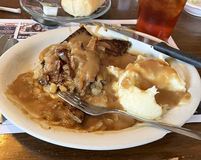 Liver and onions—the dish that separates food tourists from true comfort food aficionados—swimming in gravy that demands bread for sopping.
